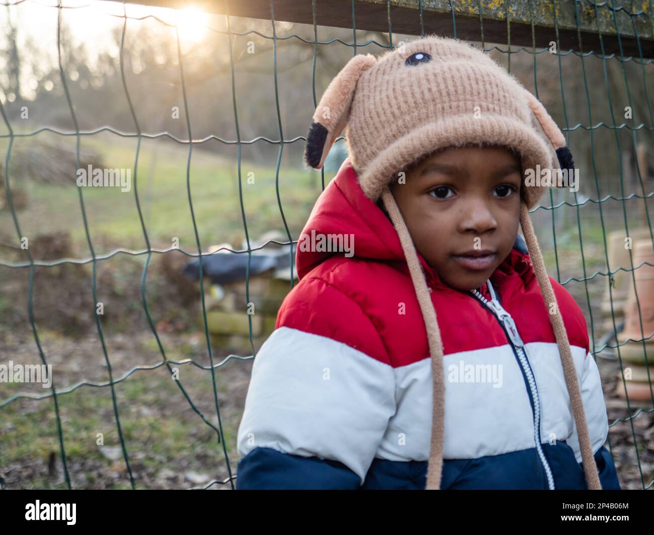portrait of african kid sta ding outdoors in a park a sunny day wearing ...