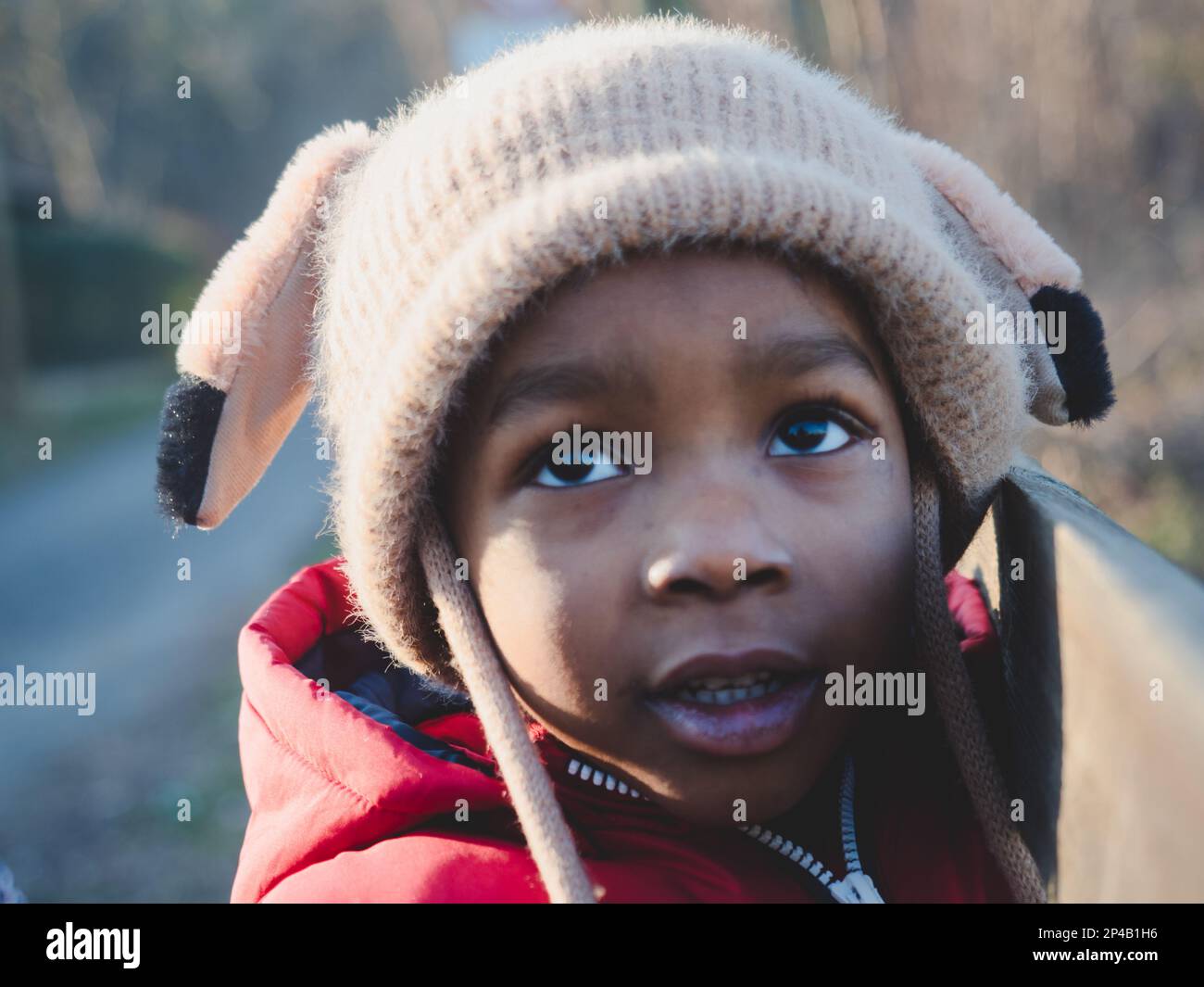 portrait of african kid sta ding outdoors in a park a sunny day wearing ...