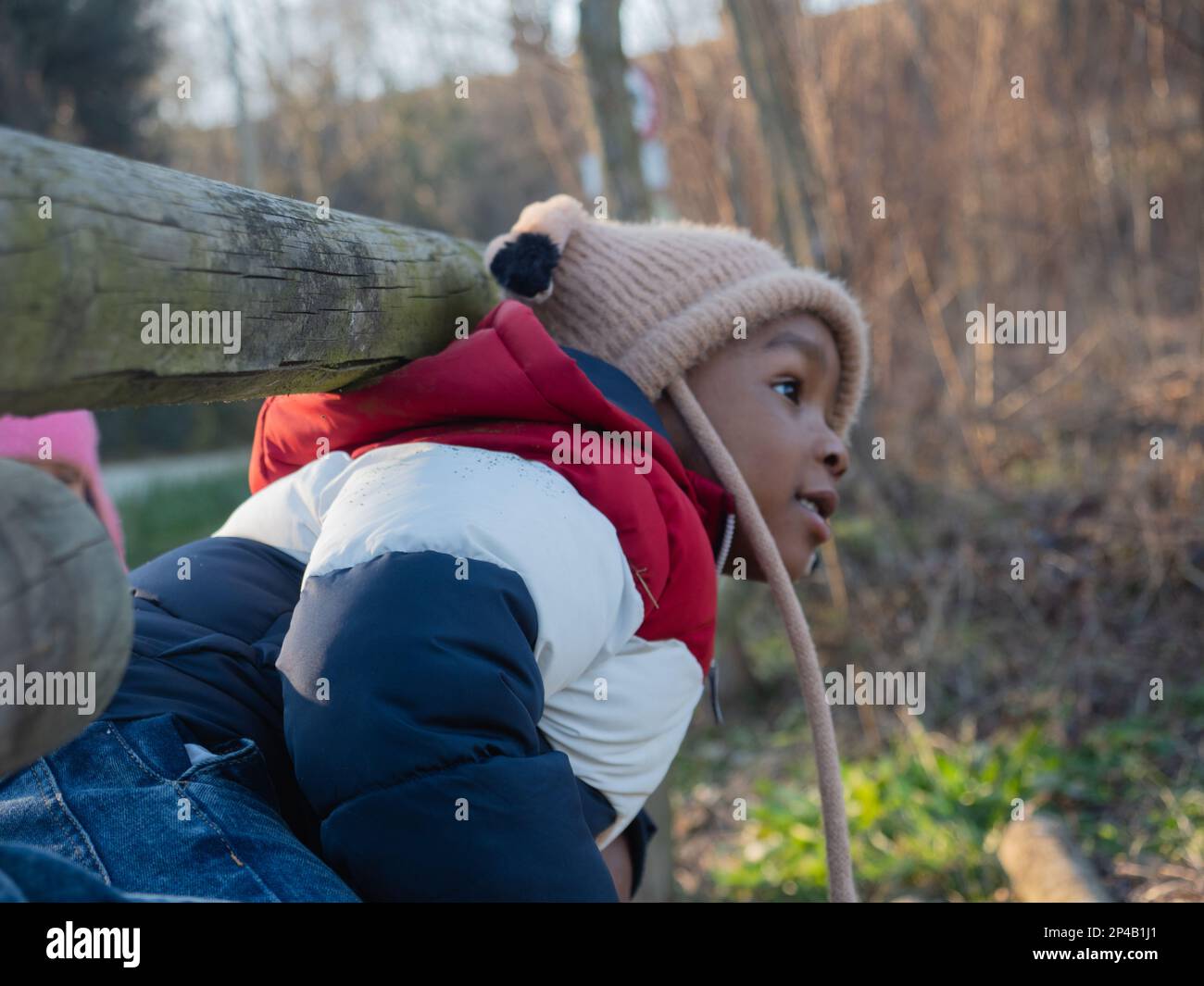 portrait of african kid sta ding outdoors in a park a sunny day wearing ...