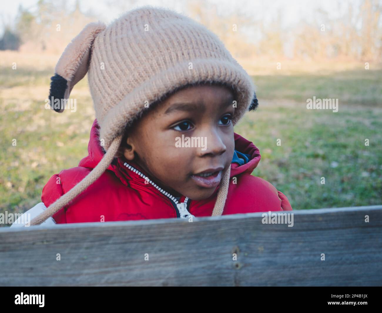 portrait of african kid sta ding outdoors in a park a sunny day wearing ...