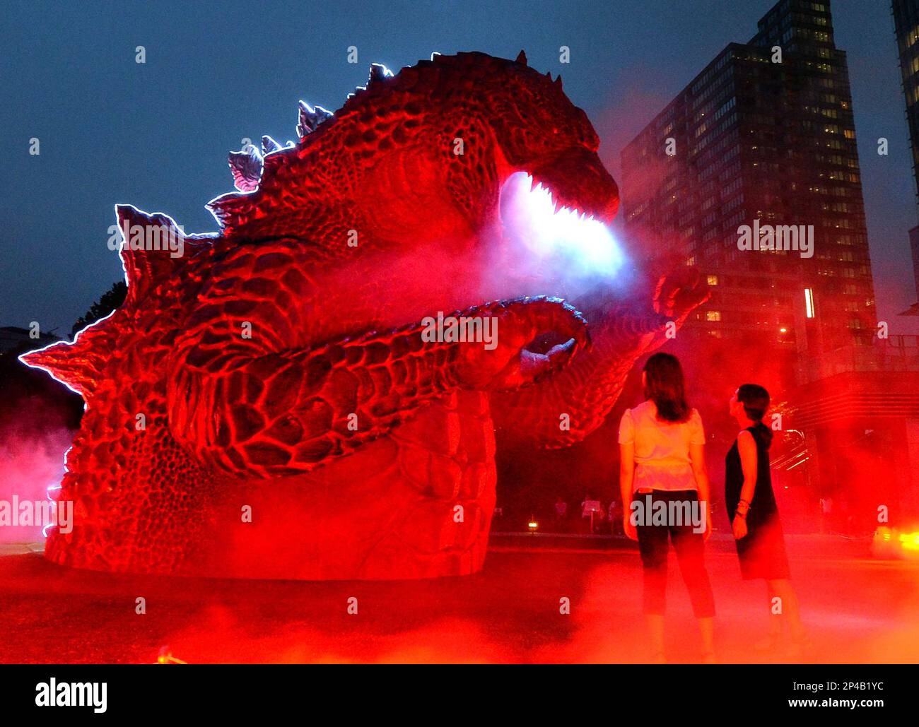 A godzilla illuminated in the night roars at Tokyo Midtown, a shopping ...