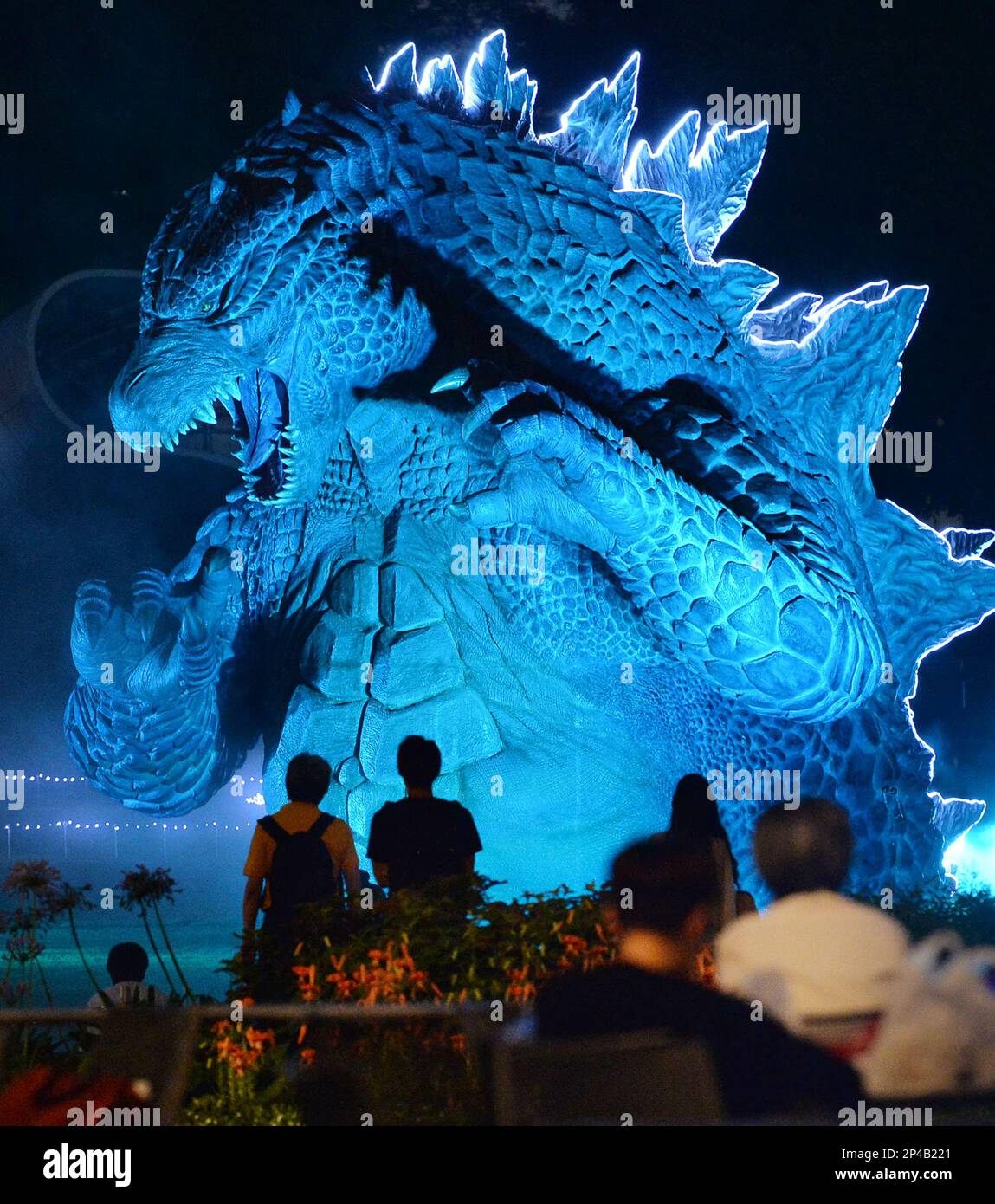 A godzilla illuminated in the night roars at Tokyo Midtown, a shopping ...