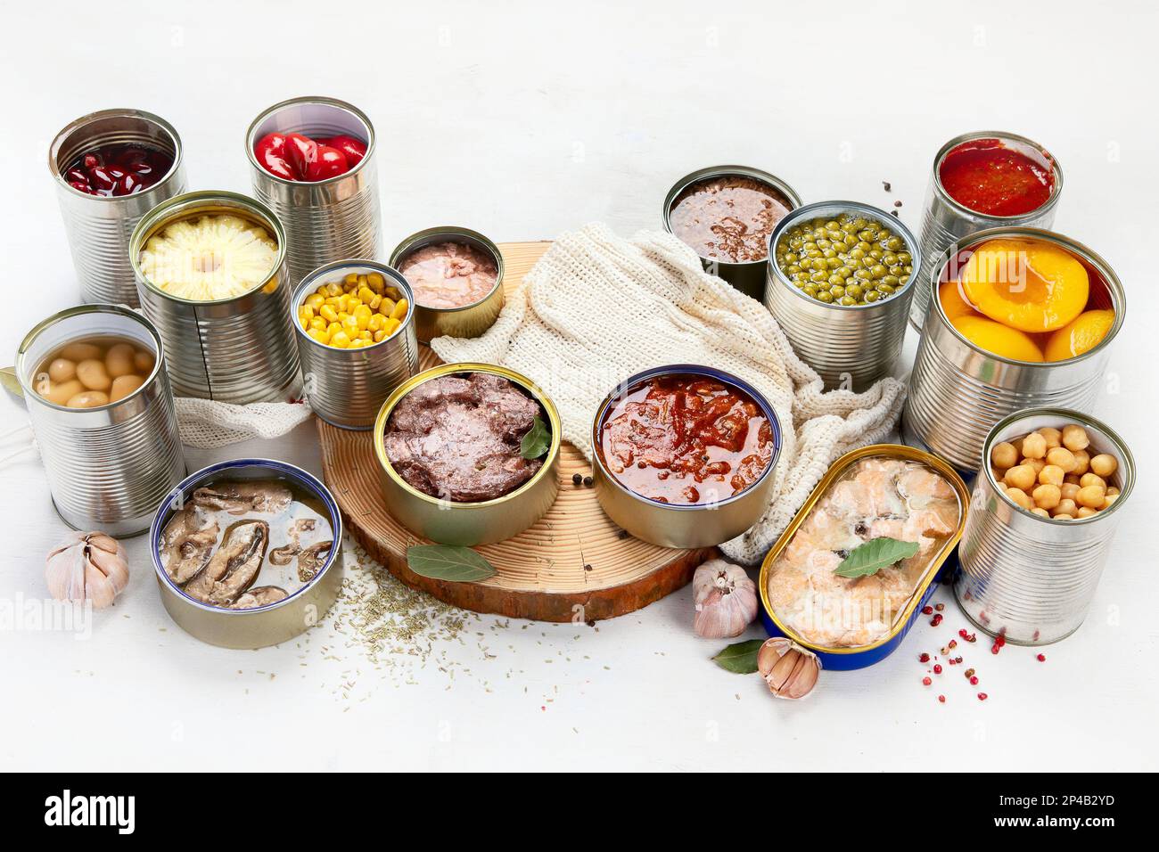 Various canned vegetables, meat, fish and fruits in tin cans. On a ...