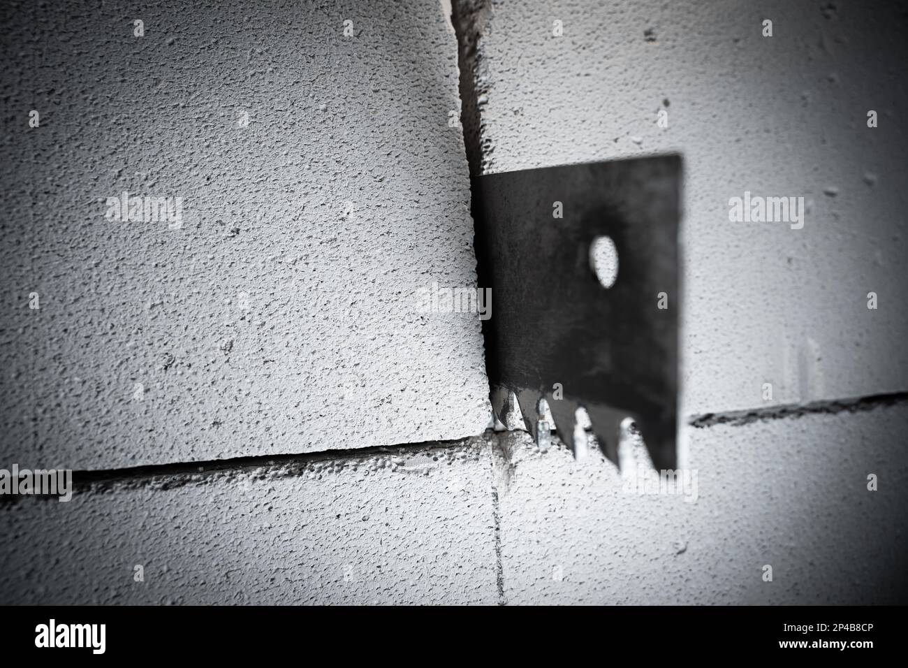 A hacksaw for aerated concrete sticks out of a wall of aerated concrete ...
