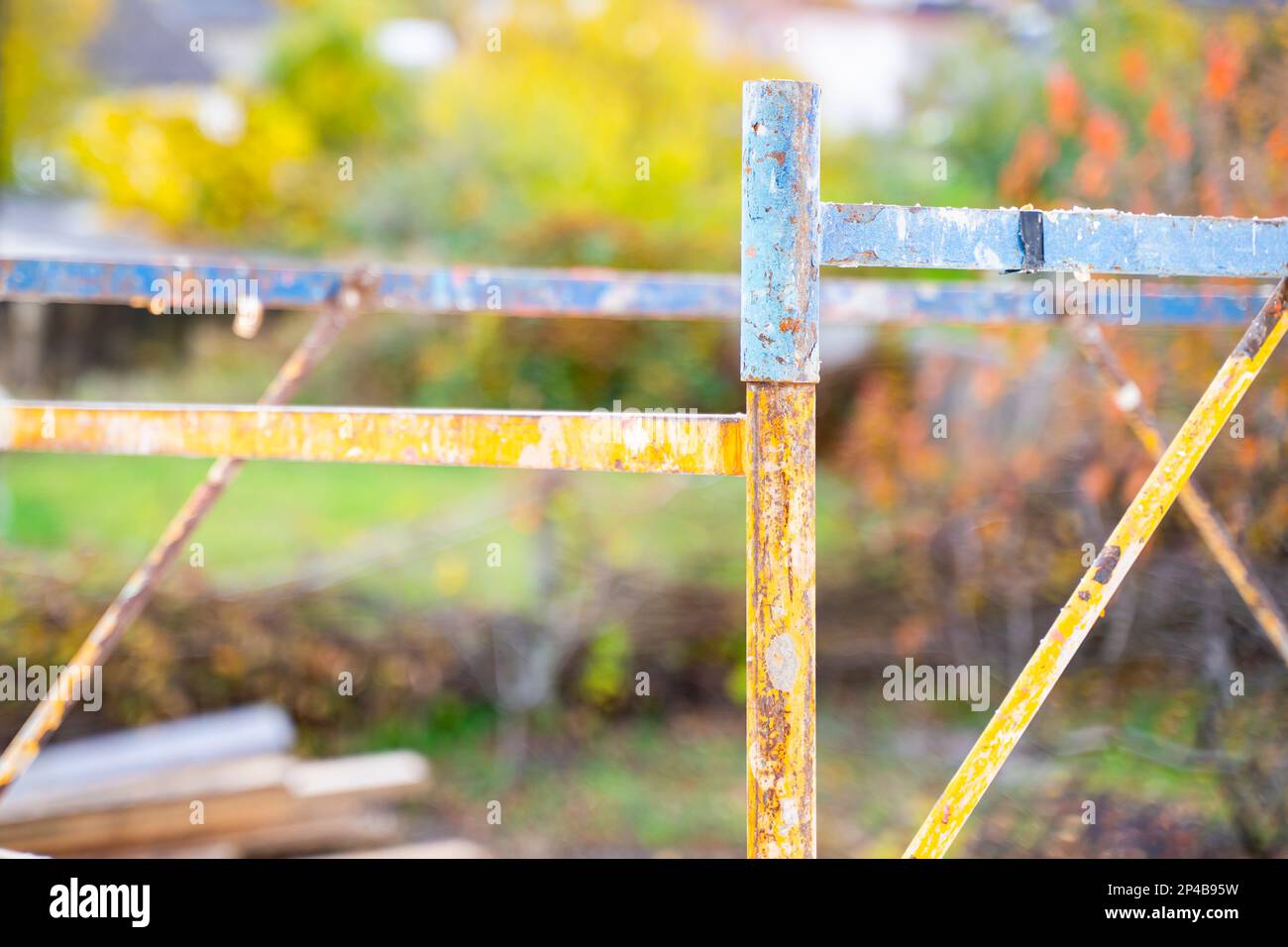 Old iron scaffolding on a blurred background. Construction of yellow ...