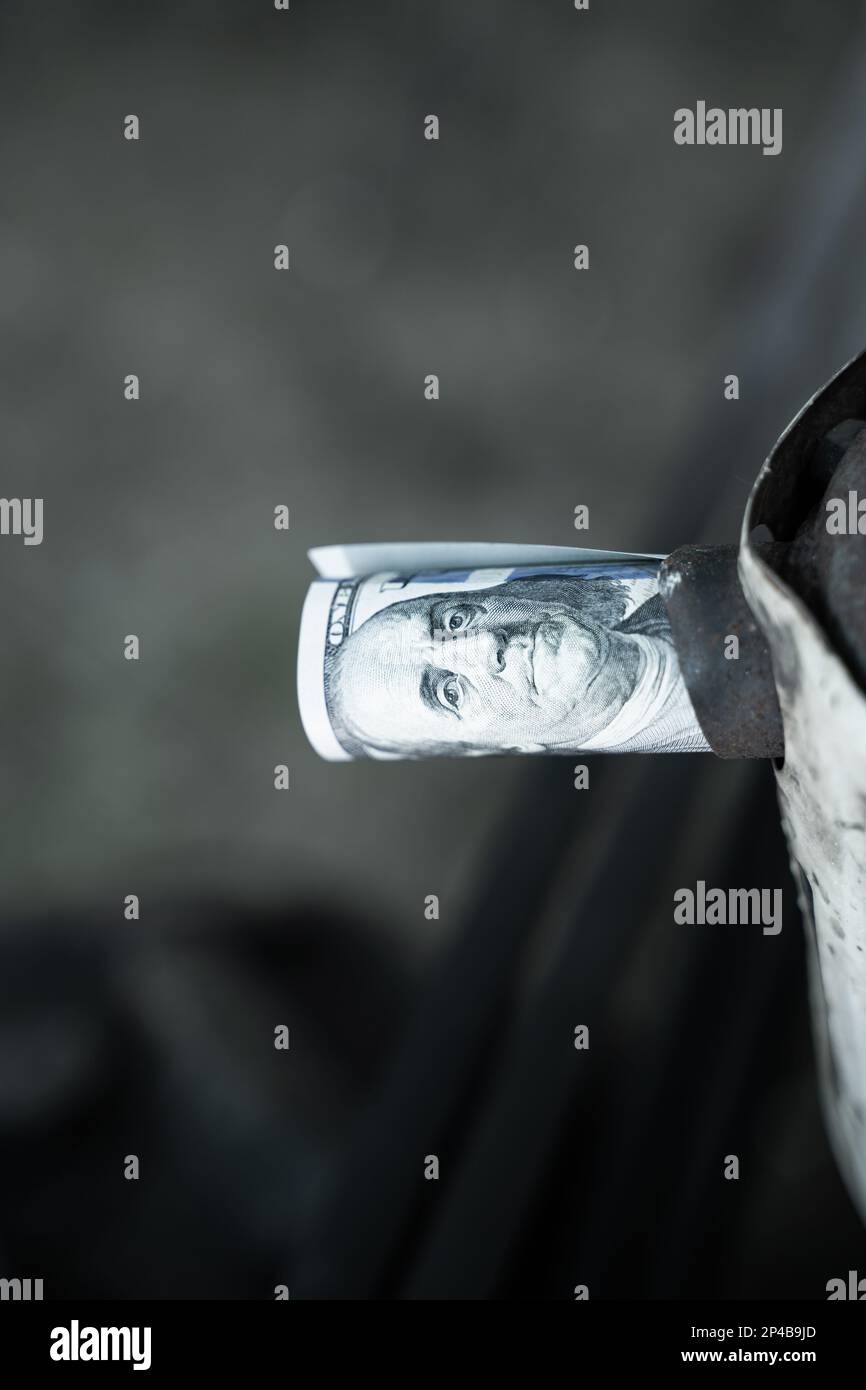 Vertical photo of dollars in an exhaust pipe. Money and the ...