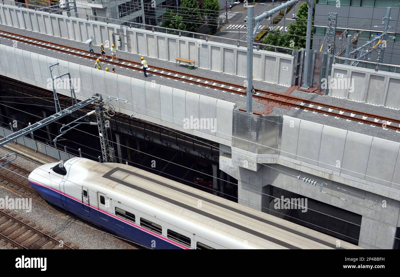 People in Tokyo walk on newly built tracks (upper) between Akihabara ...