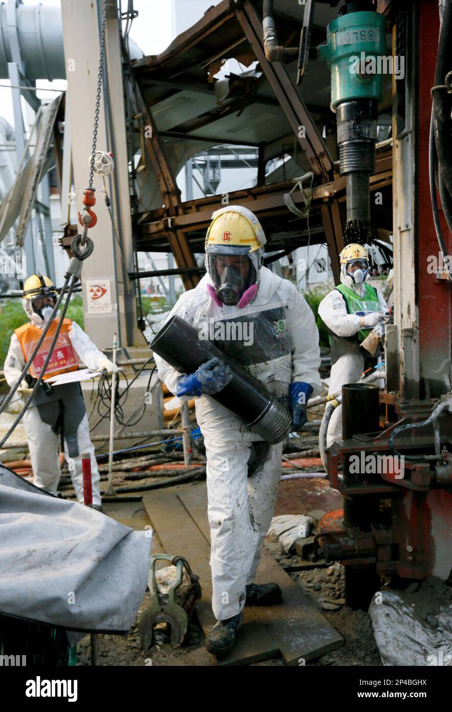 A workers carries a pipe which will be used to create a frozen ...