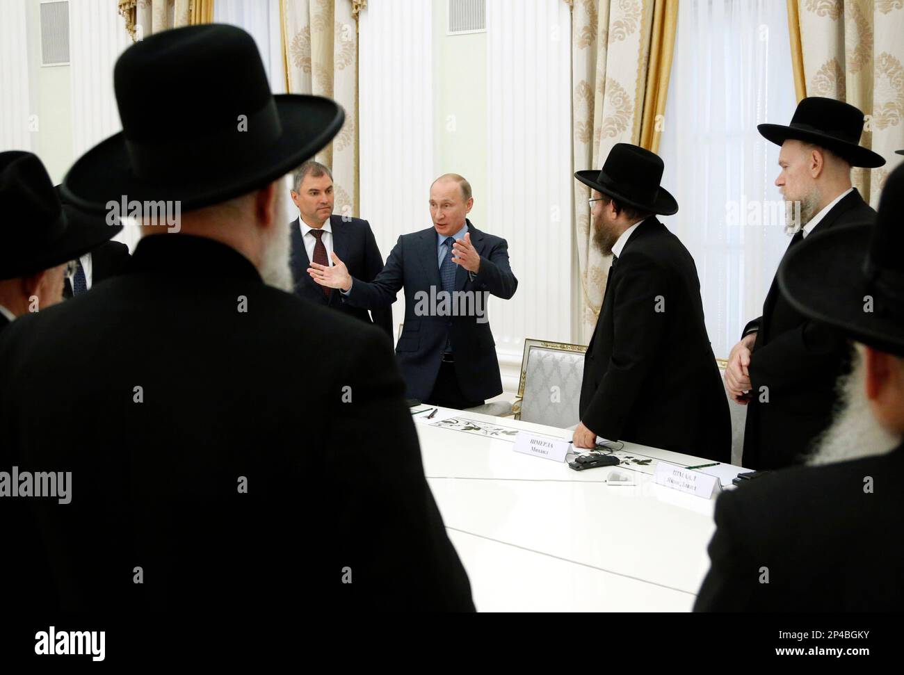 Russian President Vladimir Putin, background center, welcomes members ...