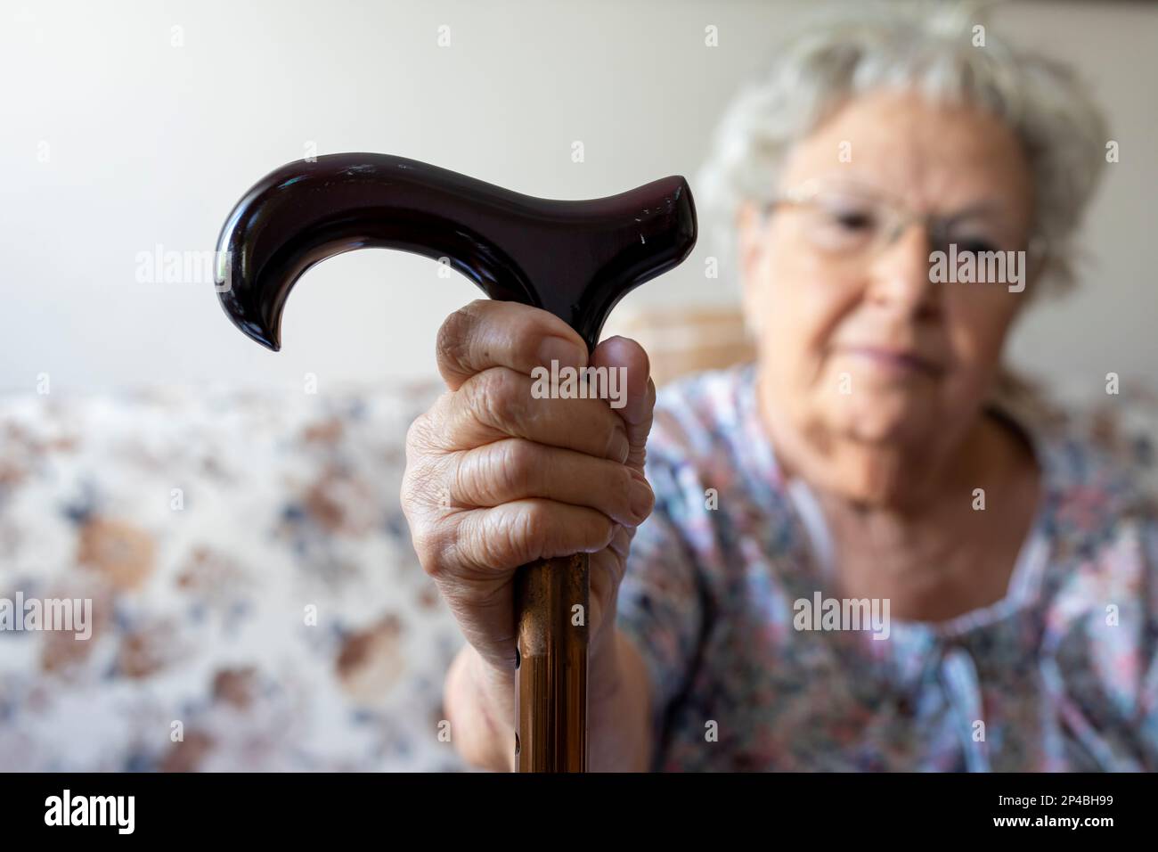 Old woman holding walking stick hi-res stock photography and images - Alamy