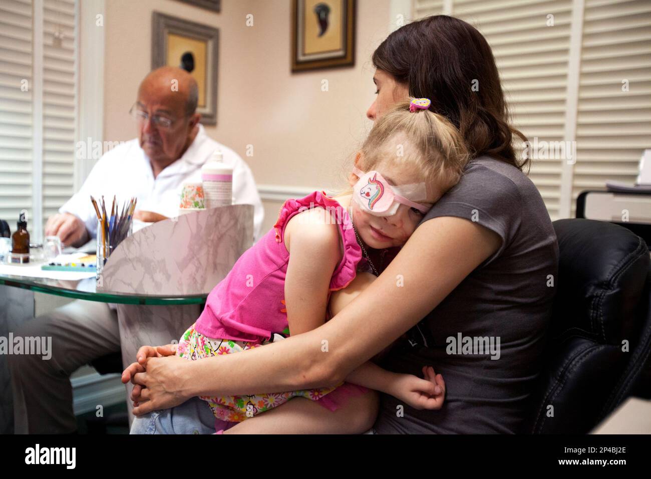 Victoria Wilcher, 3, of Jackson, Mississippi, sits with her mother ...