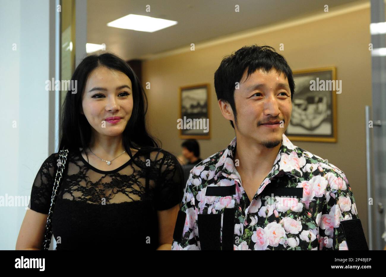 Chinese boxer Zou Shiming, right, and his wife pose at an interview ...