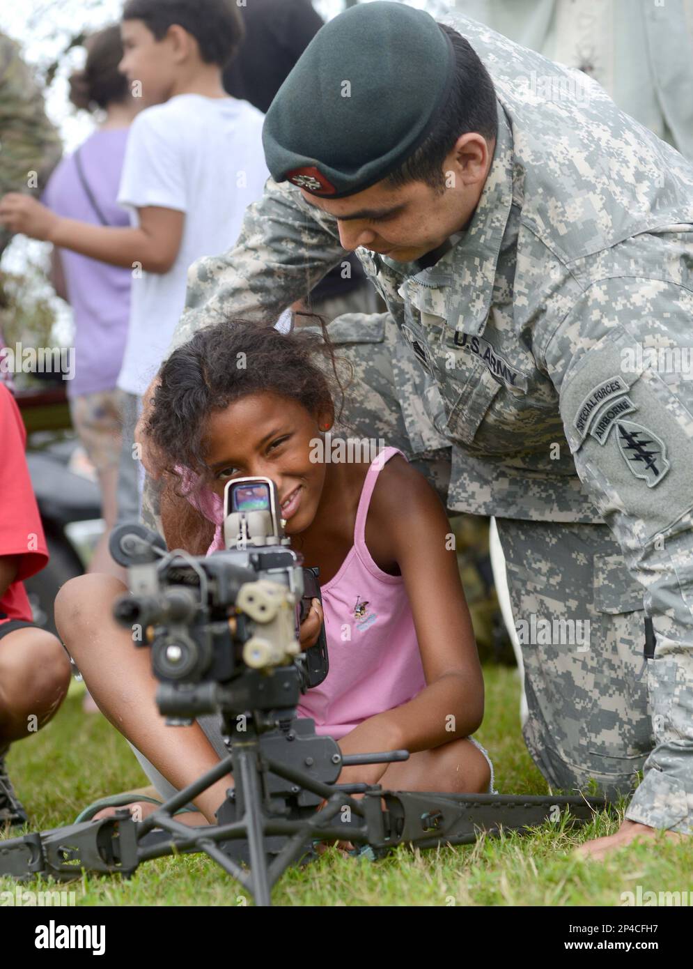 Naomi England, 8, looks through the sights of a rifle alongside Army ...