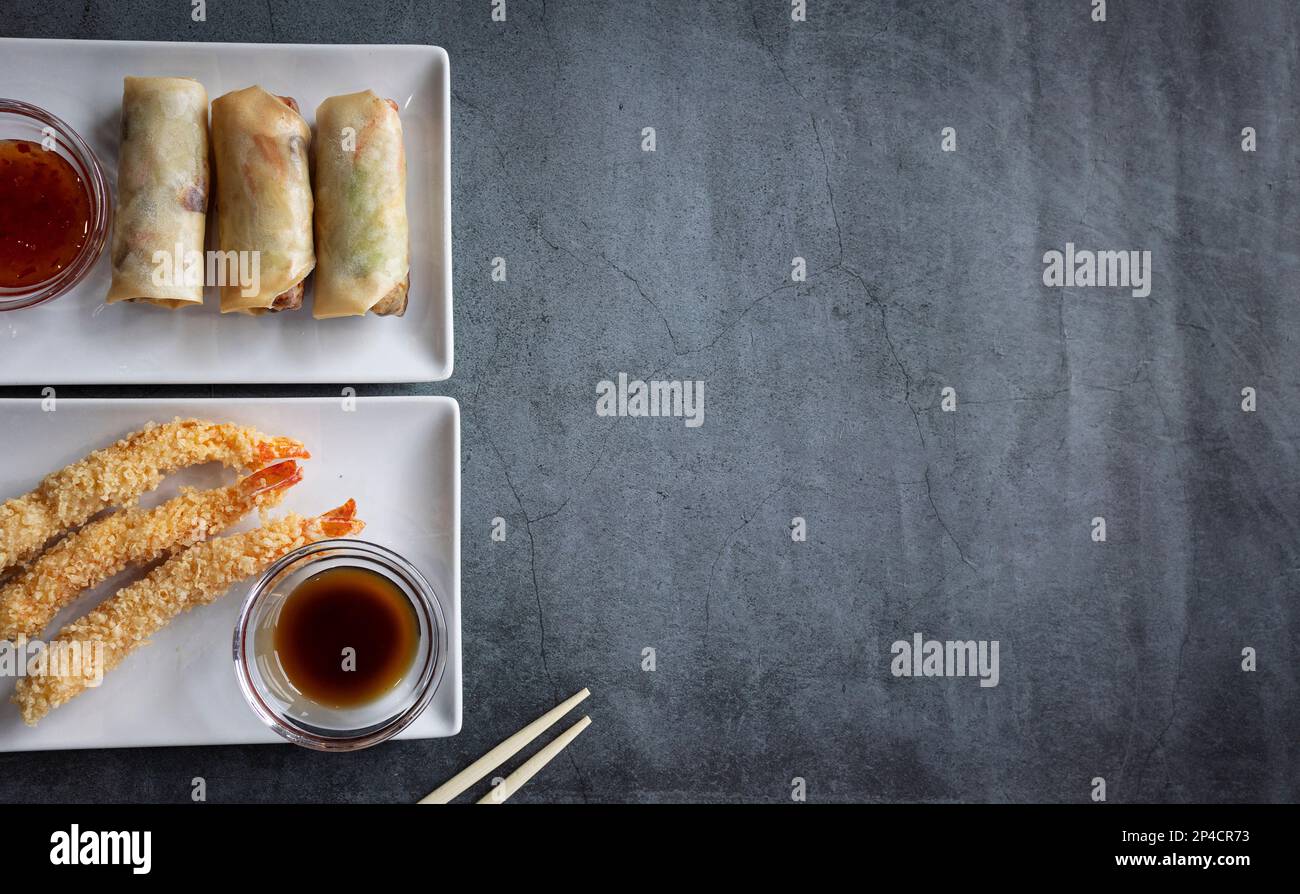 Spring rolls, sweet and sour sauce, shrimp tempura and soybeans on ...