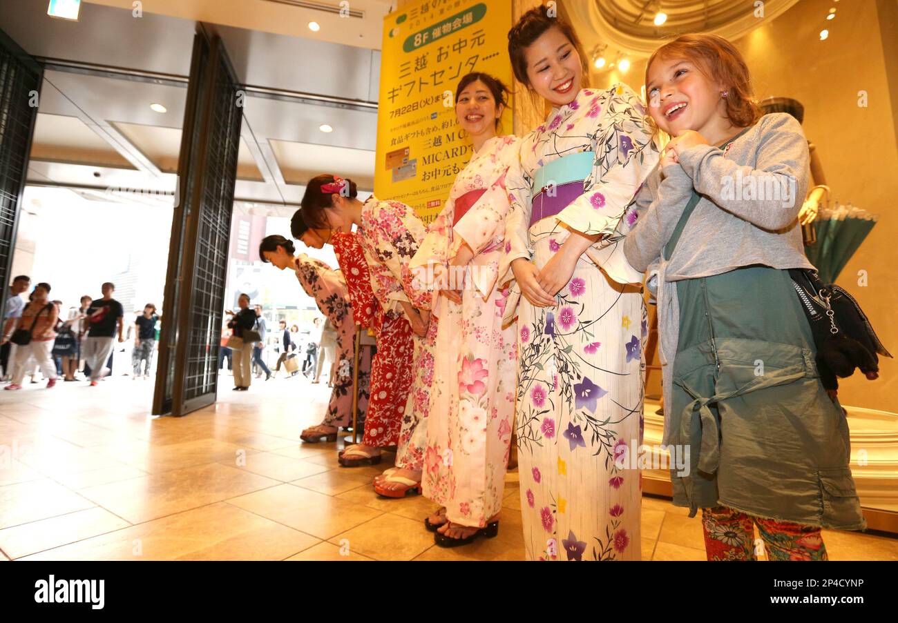 Clerks in colorful yukata summer kimono pose with a young German girl ...