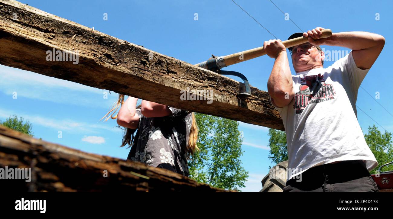 Curt Richter, right, and his son Noah use a log carrier to pick up a ...