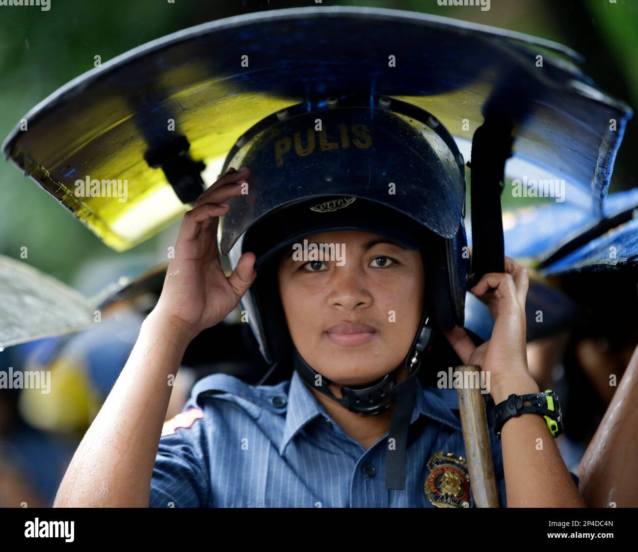 A female riot police officer uses her riot shield to protect herself ...