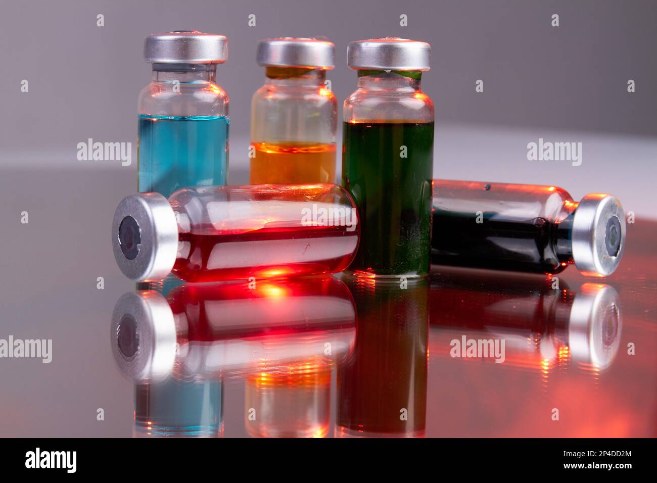 Collection of drug vials with colored solution. Vaccine bottles on ...