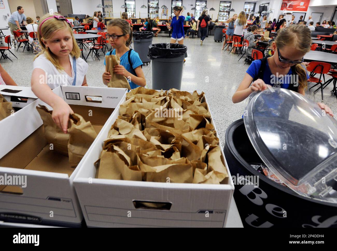 Morgan Booher, 10, front left, reaches for a bagged lunch Tuesday, June ...