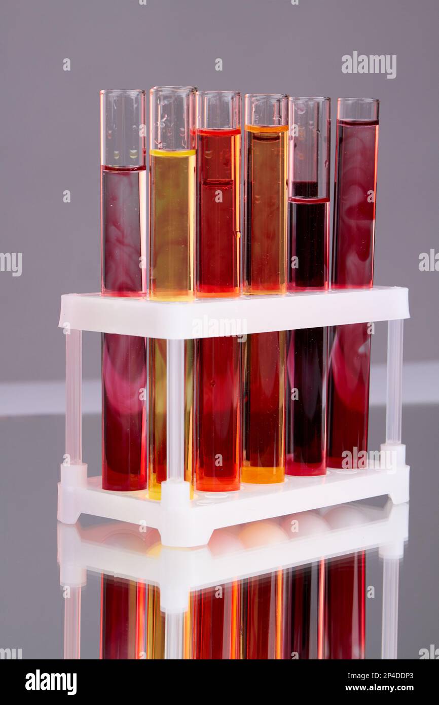 Vertical shot of colorful laboratory test tubes with blood. Reflective ...
