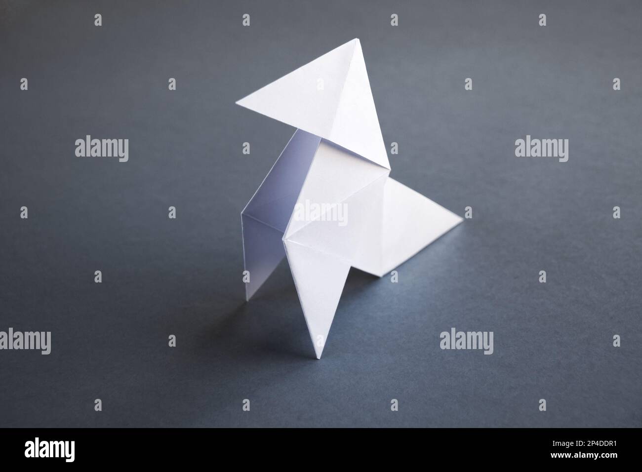 White paper hen origami isolated on a blank grey background. Cocotte en ...
