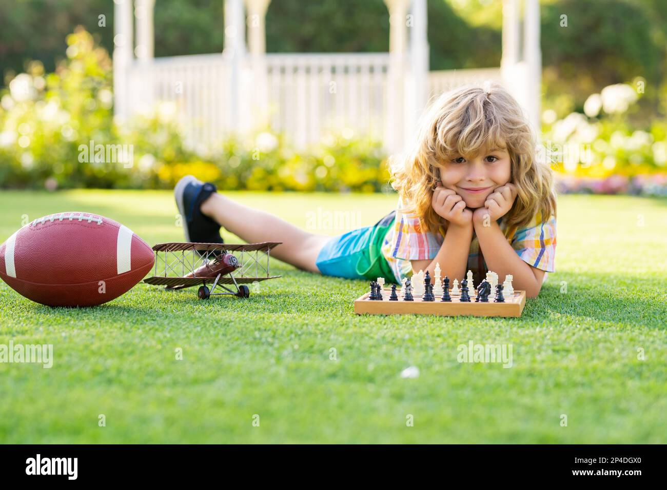 Dream kids and childhood concept. Child playing chess game in spring ...