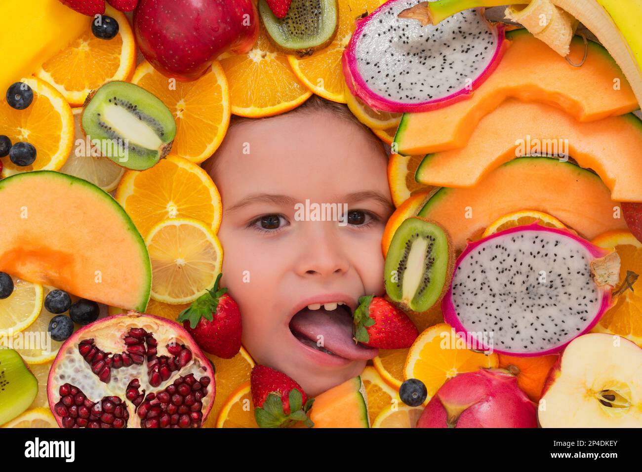Kid licking strawberry. Healthy food background. Studio photo of ...