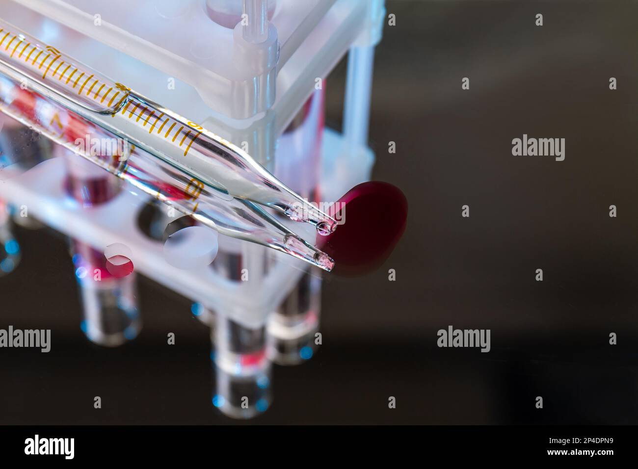 Glass pipette with blood on reflective surface. Lab glassware equipment ...