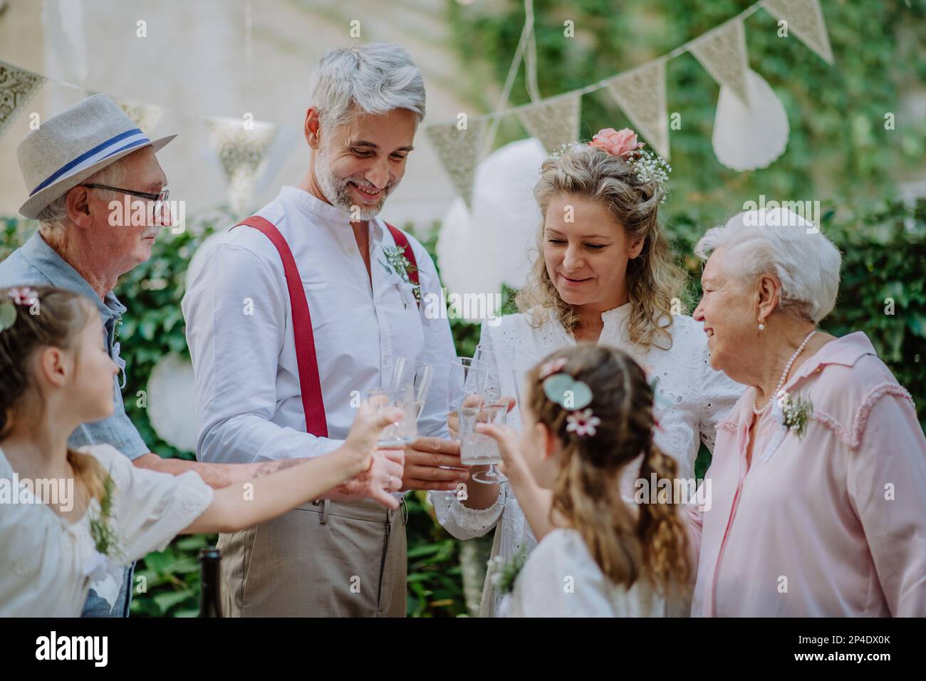 Mature bride and groom toasting with family at wedding reception ...