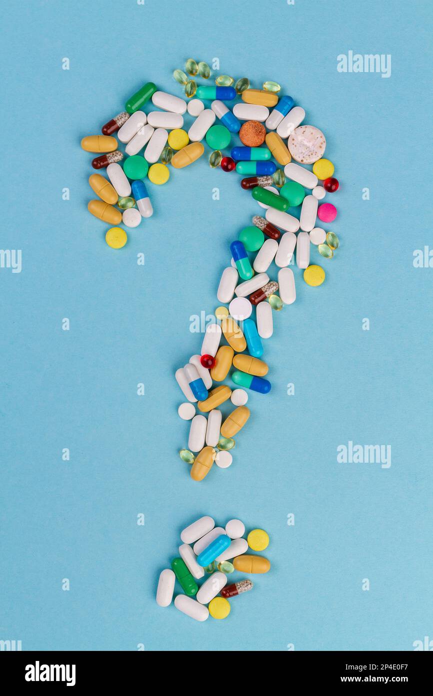Vertical shot of question mark made of pills. Top view blue background ...