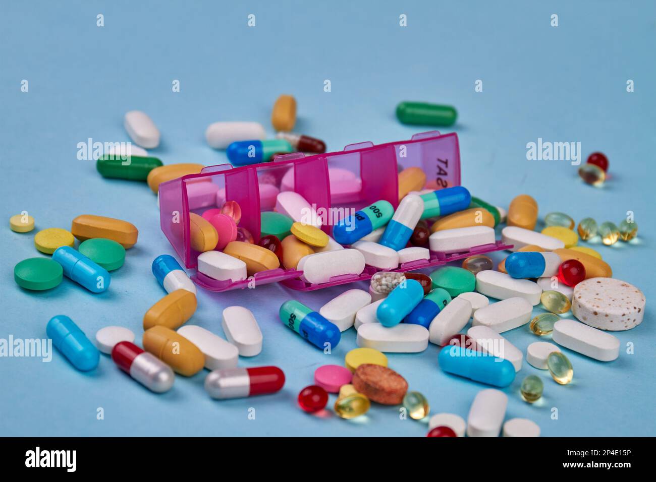Purple plastic pills organizer and pile different tablets. Medicine on ...