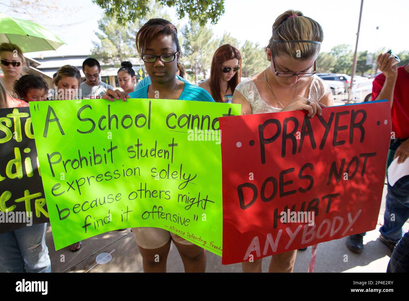 Parents and students bow their heads Monday afternoon, June 2, 2014 as ...