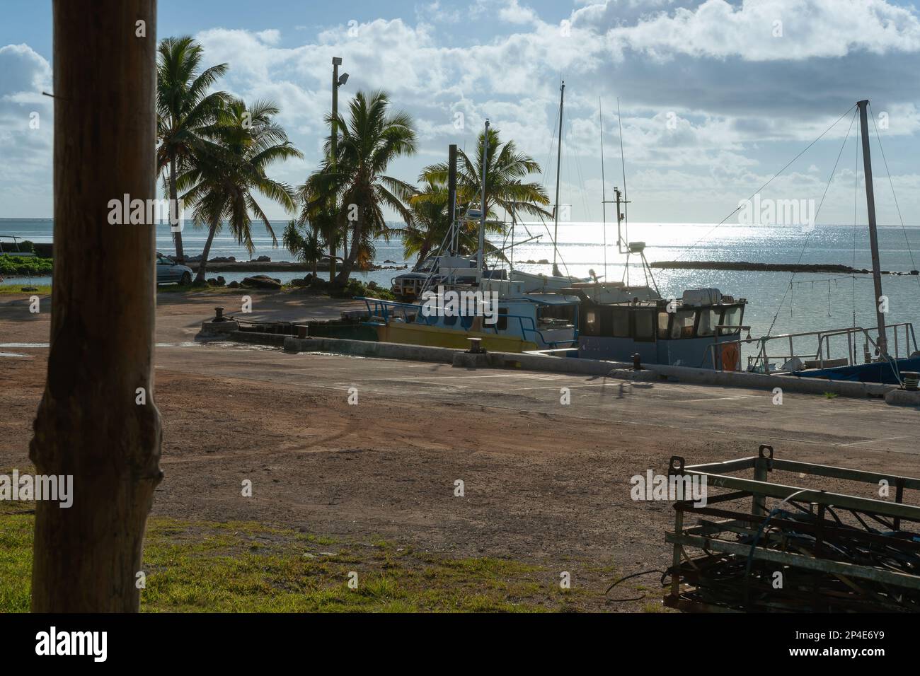 Fishing boats moored at wharf in Cook Islands. back-lit by sun Stock ...