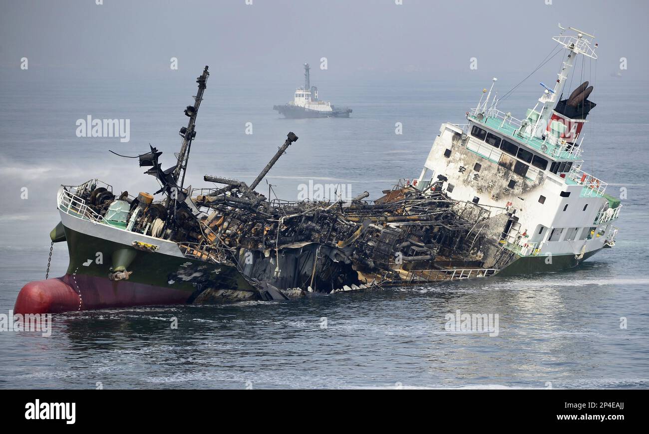The Shoko Maru, a 998-ton tanker, gutted by fire tilts after it ...