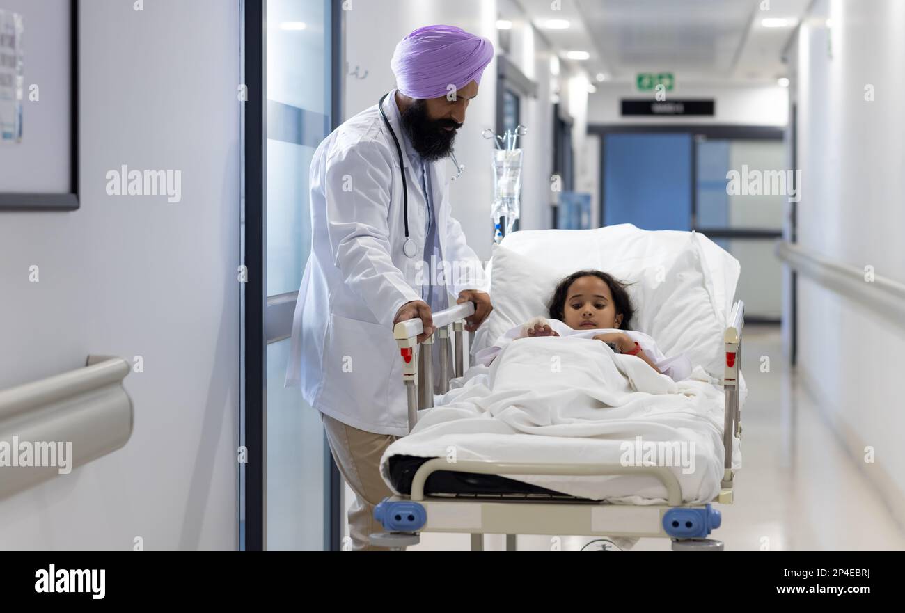 Sikh male doctor in turban with girl lying on hospital bed Stock Photo ...