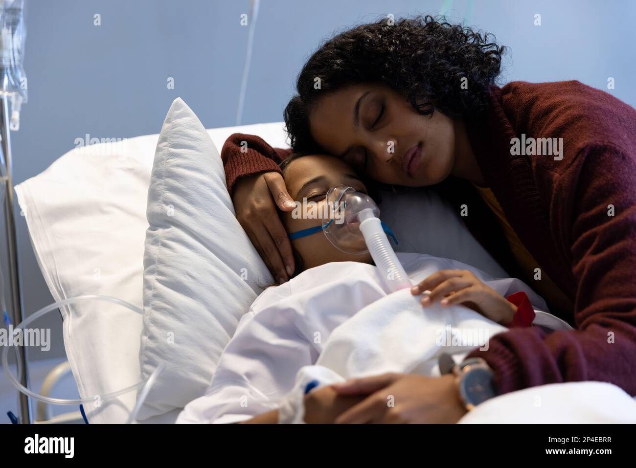 Sick biracial daughter with mother with oxygen mask and teddy bear ...