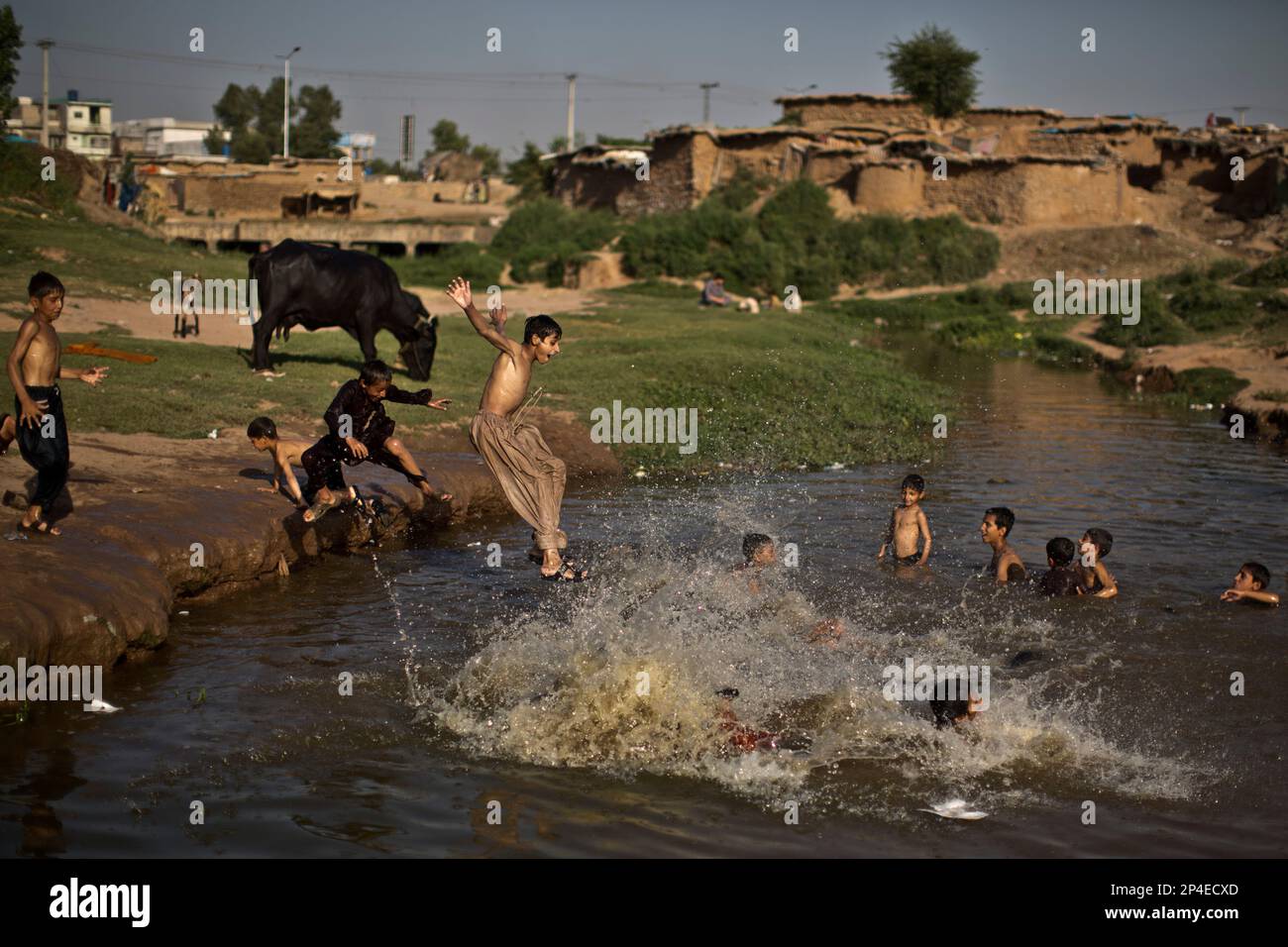 An Afghan refugee boy, center, jumps into the water, while he and ...
