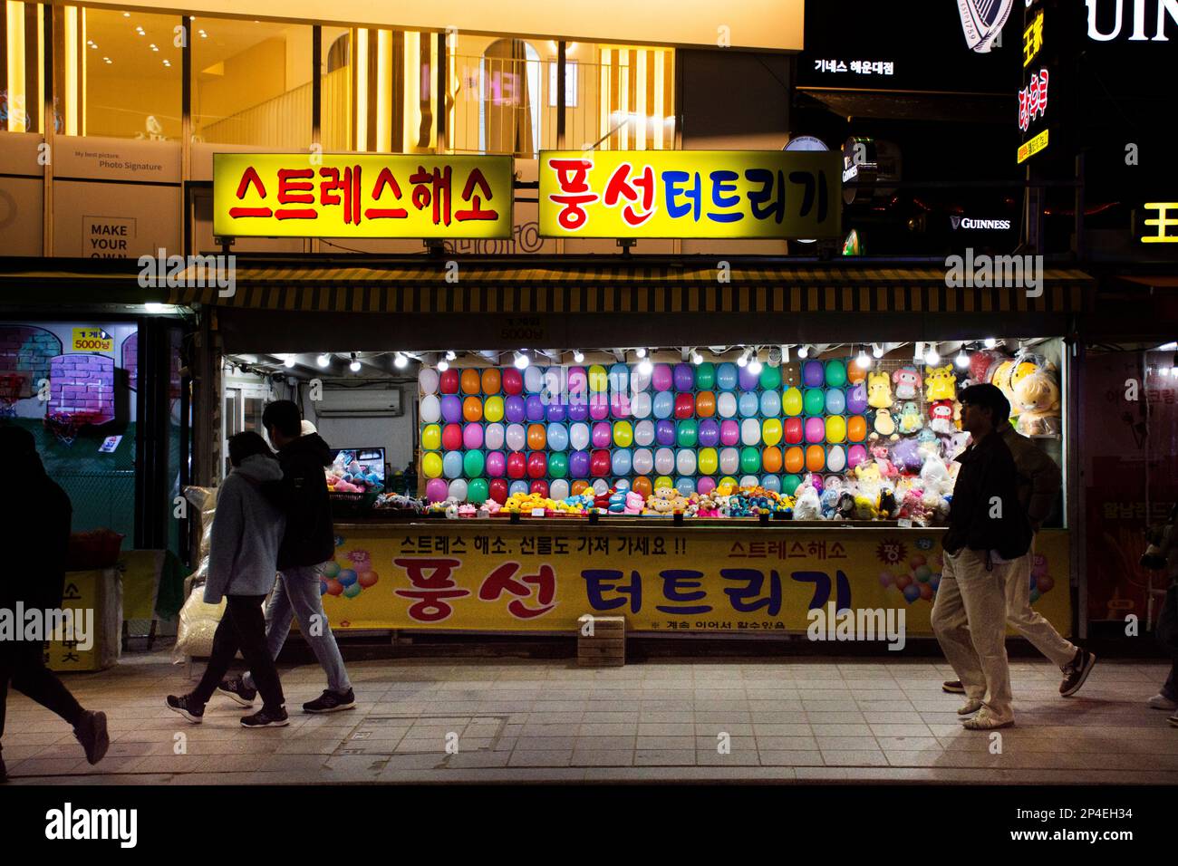 Balloon popping and darts game arcade shop in carnival games at Haeundae street night market for ...