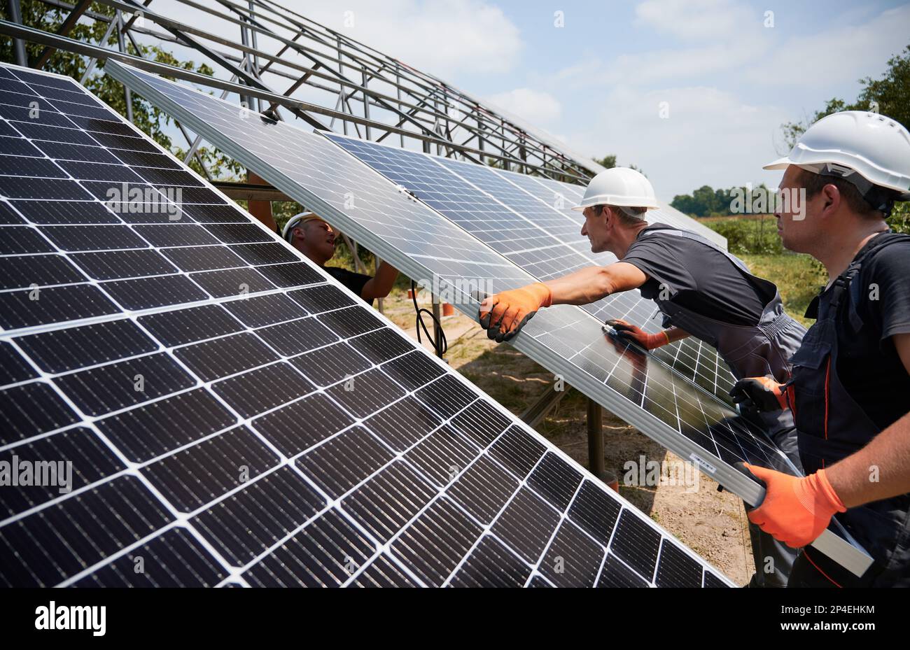 Male workers installing photovoltaic solar panel system outdoors. Men ...