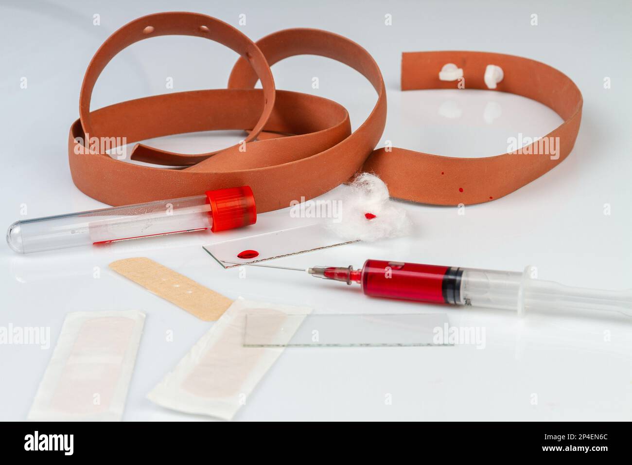 Close up of syringe filled with blood and tourniquet. Patches and glass ...