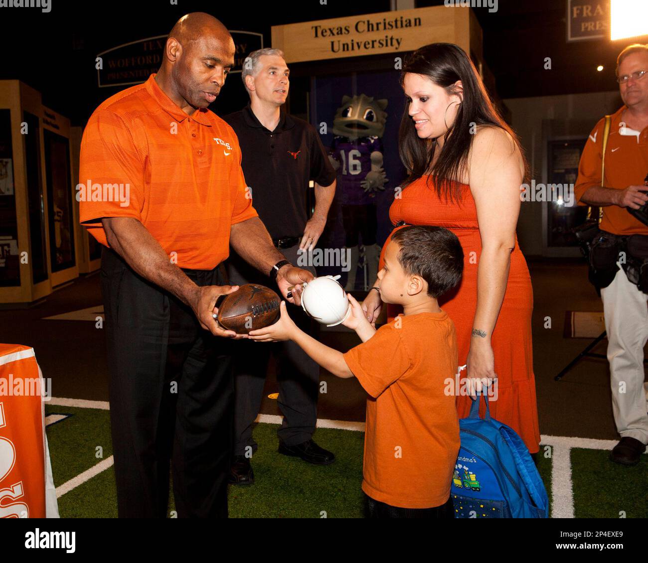 Texas ootball coach Charlie Strong Signs a football and a Texas ...