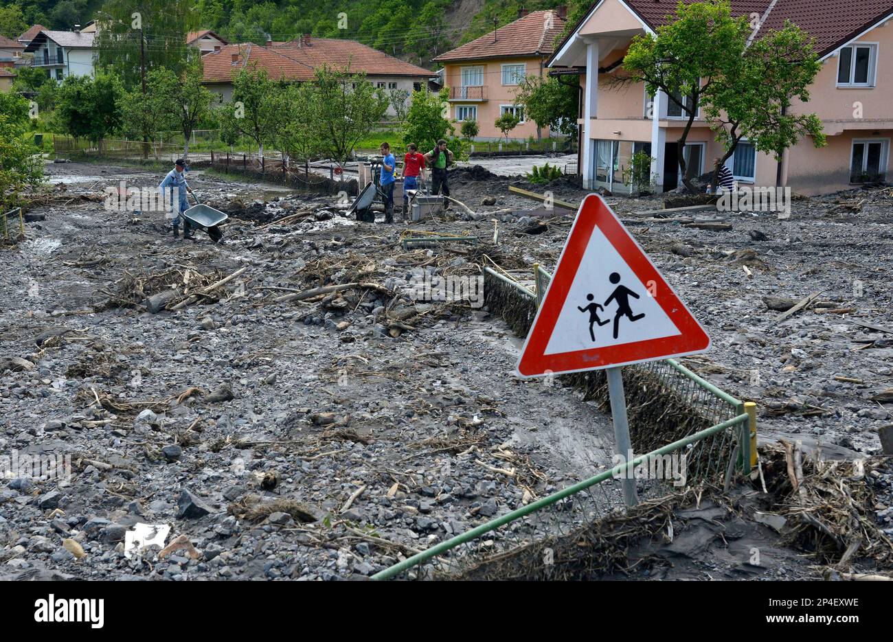 Residents clean streets of mud and rubble after a landslide at the ...