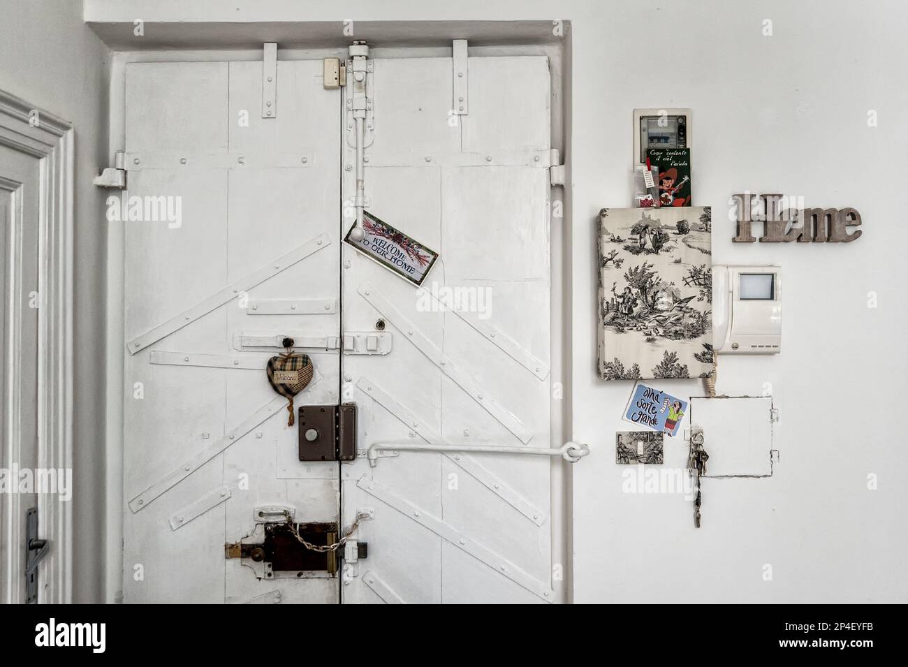 Closed white door of home interior with various objects hanging on the ...