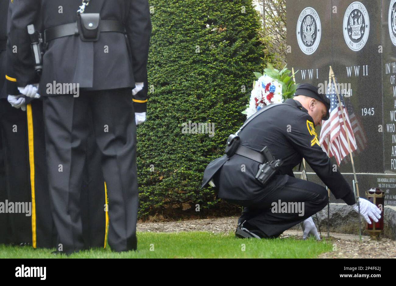 Detective Cpl. David Roddick, right, places an eternal flame at the war ...