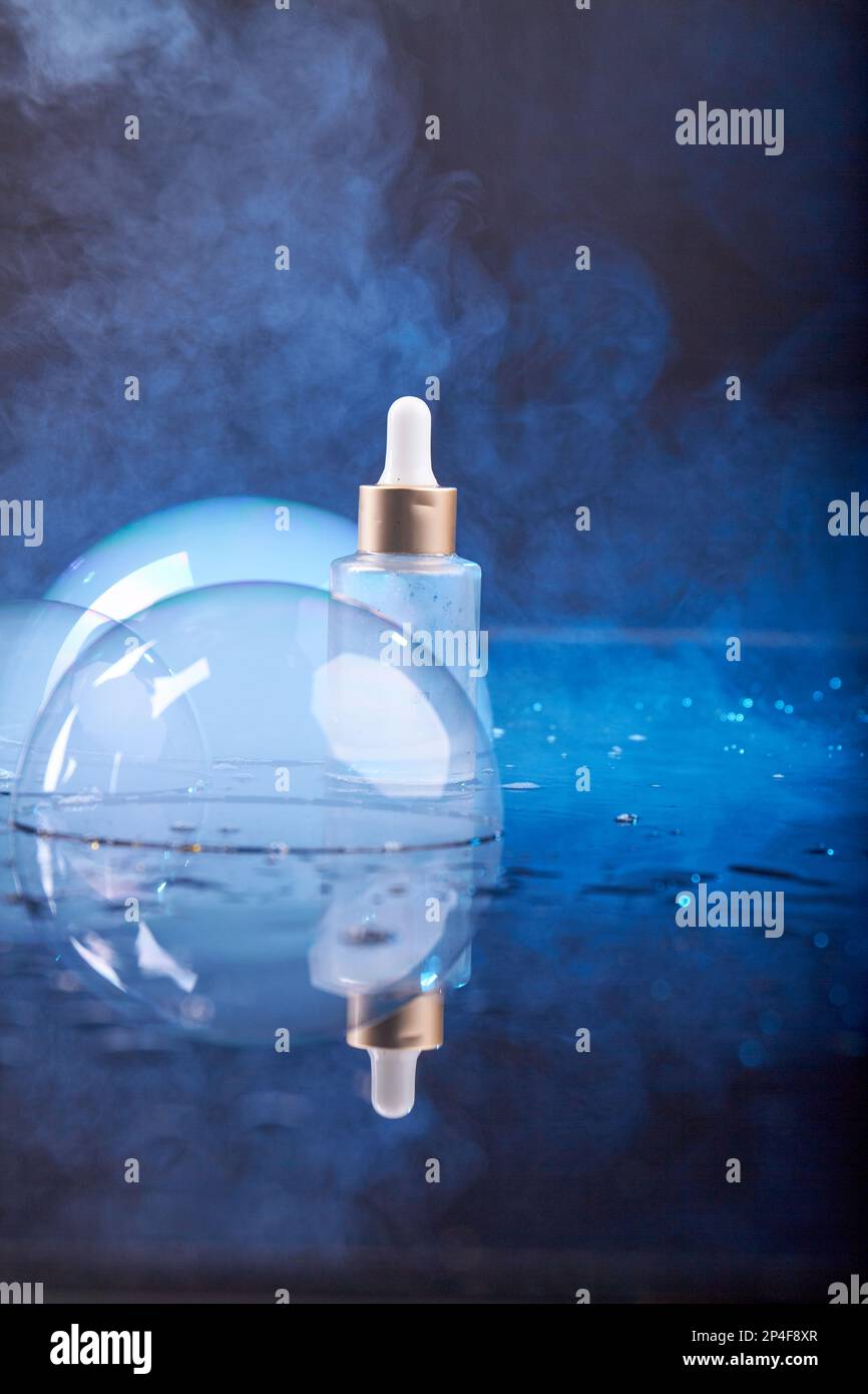 Vertical shot of perfume bottle with bubble and steam vapor. Blue and ...