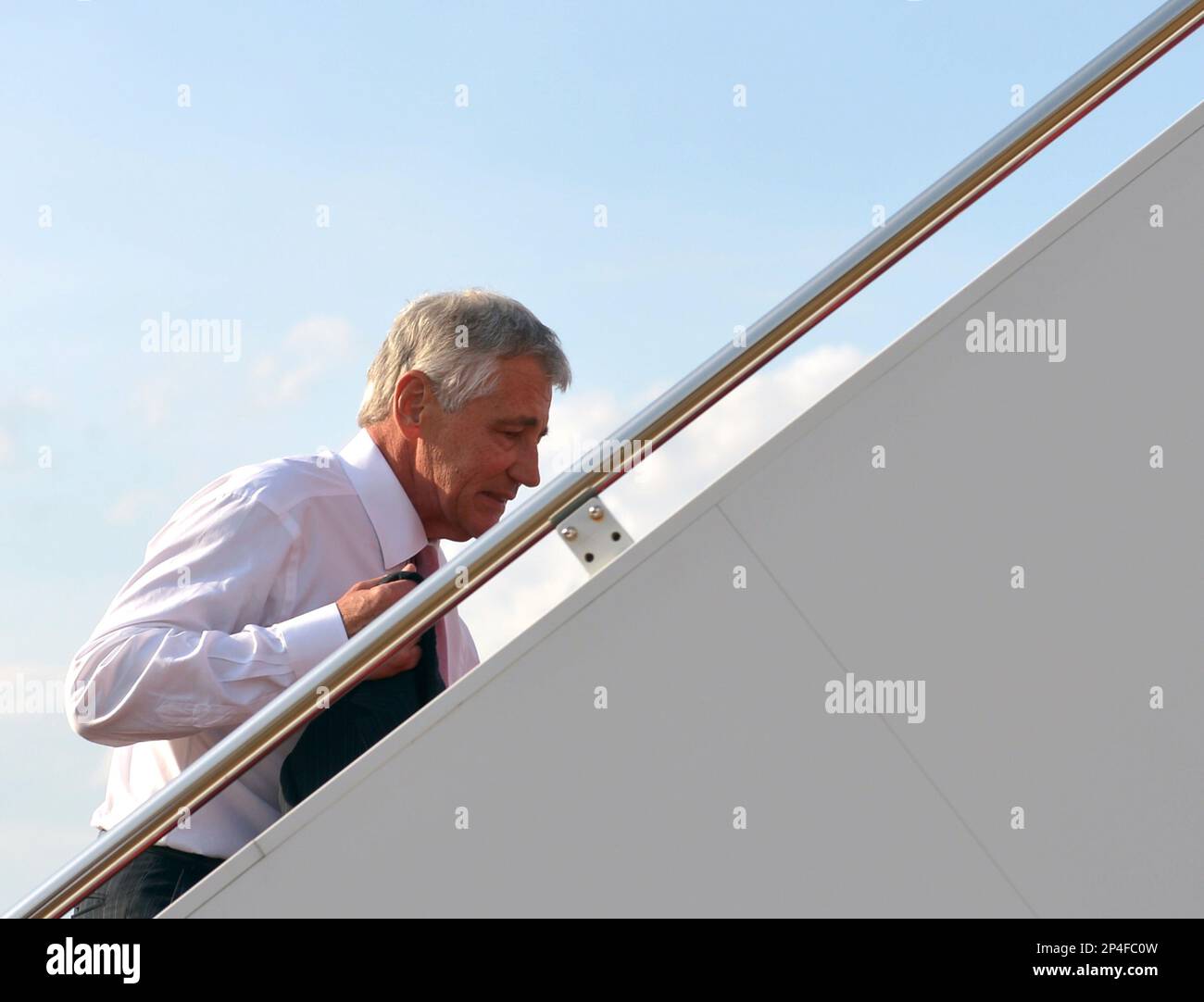 Defense Secretary Chuck Hagel boards a flight at Andrews Air Force Base ...