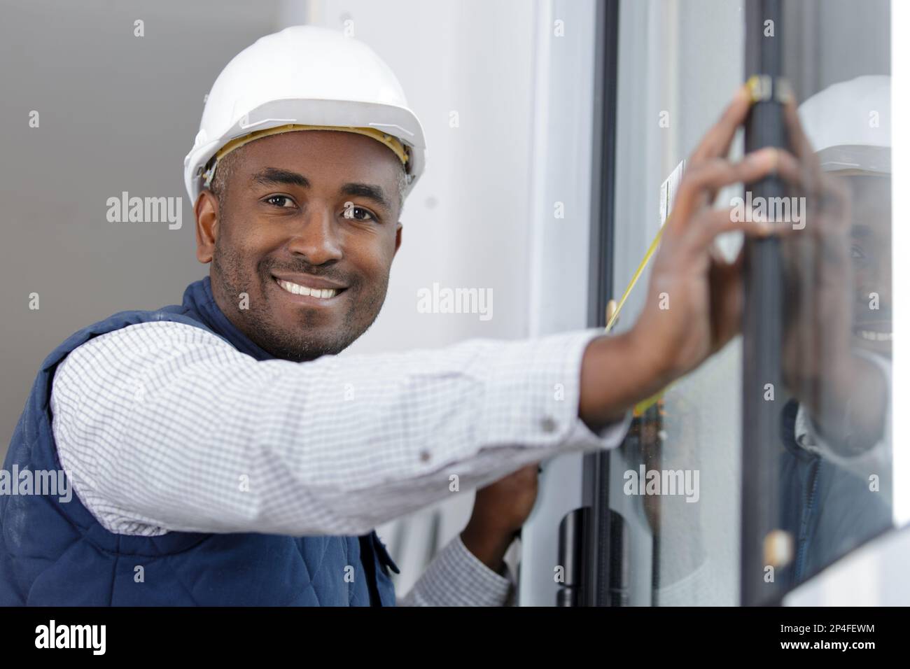 builder measuring a window using a tape measure Stock Photo - Alamy