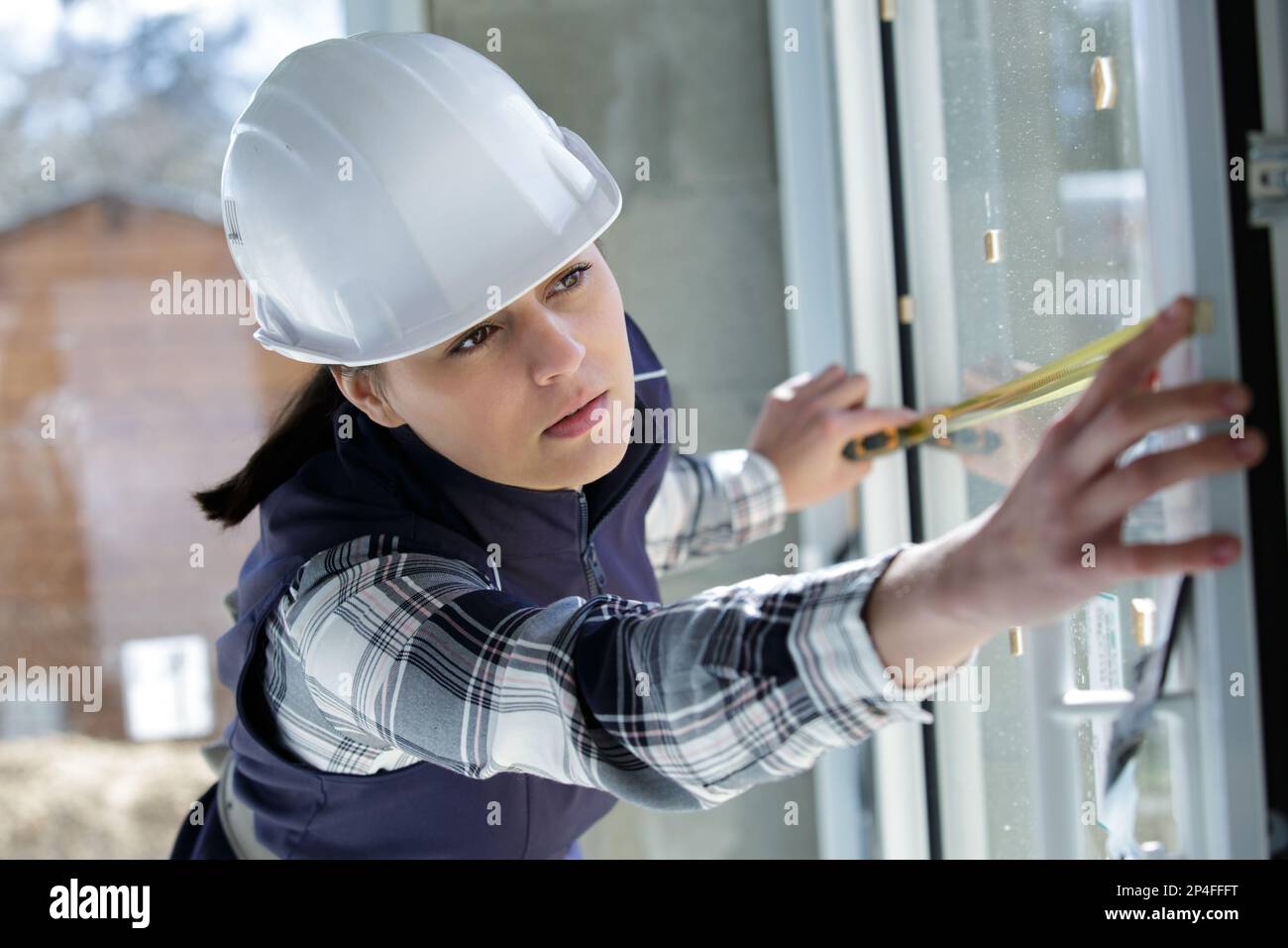 happy beautiful woman builder with tape measure Stock Photo - Alamy