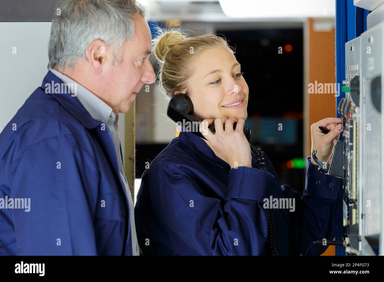 apprentice using old fashioned coin operated telephone Stock Photo - Alamy