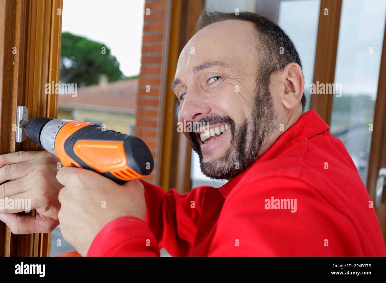 happy smiling constructor working on frame Stock Photo - Alamy